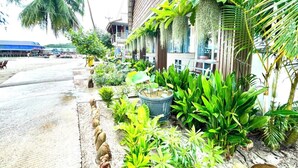 Um hotel com jardim tropical, palmeiras e um grande lago ornamental.