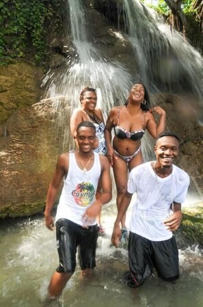 Um grupo de pessoas em frente a uma cascata.