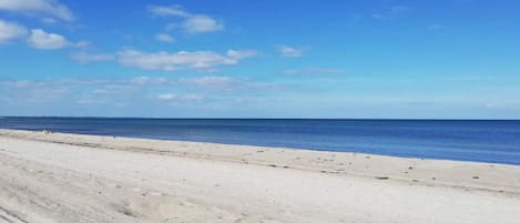 Uma praia com céu limpo e mar calmo.