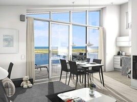 Quarto de hotel moderno com área de refeições, cozinha e varanda grande vista para o mar.