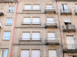 Um edifício de vários andares com varandas e grandes janelas.