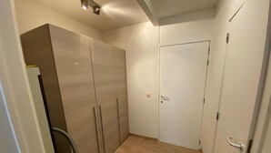 Quarto com guarda-roupa, porta e aspirador de pó.
