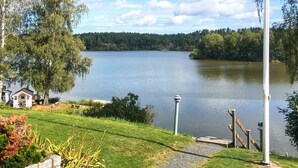 Um lago com um píer, gramado e um muro de pedra.