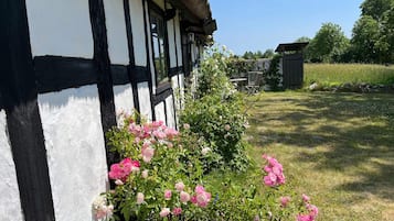 Edifício em estilo de enxaimel com um jardim de rosas cor-de-rosa.