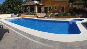 Uma área de piscina com uma casa ao fundo.