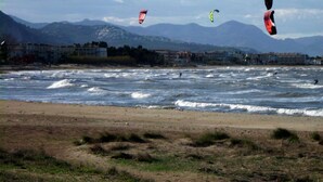 Uma praia com ondas e pipas no céu.