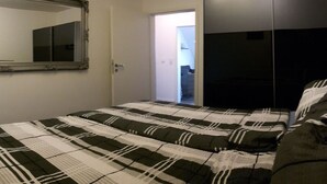 Um quarto com uma cama, um guarda-roupa e um espelho na parede.