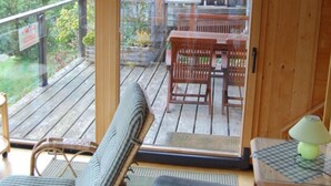 Interior de madeira com porta de vidro deslizante para um deck externo.