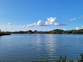 Um lago tranquilo com céu claro e nuvens esparsas.
