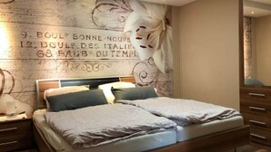 Quarto com cama, mesas de cabeceira e um espelho.