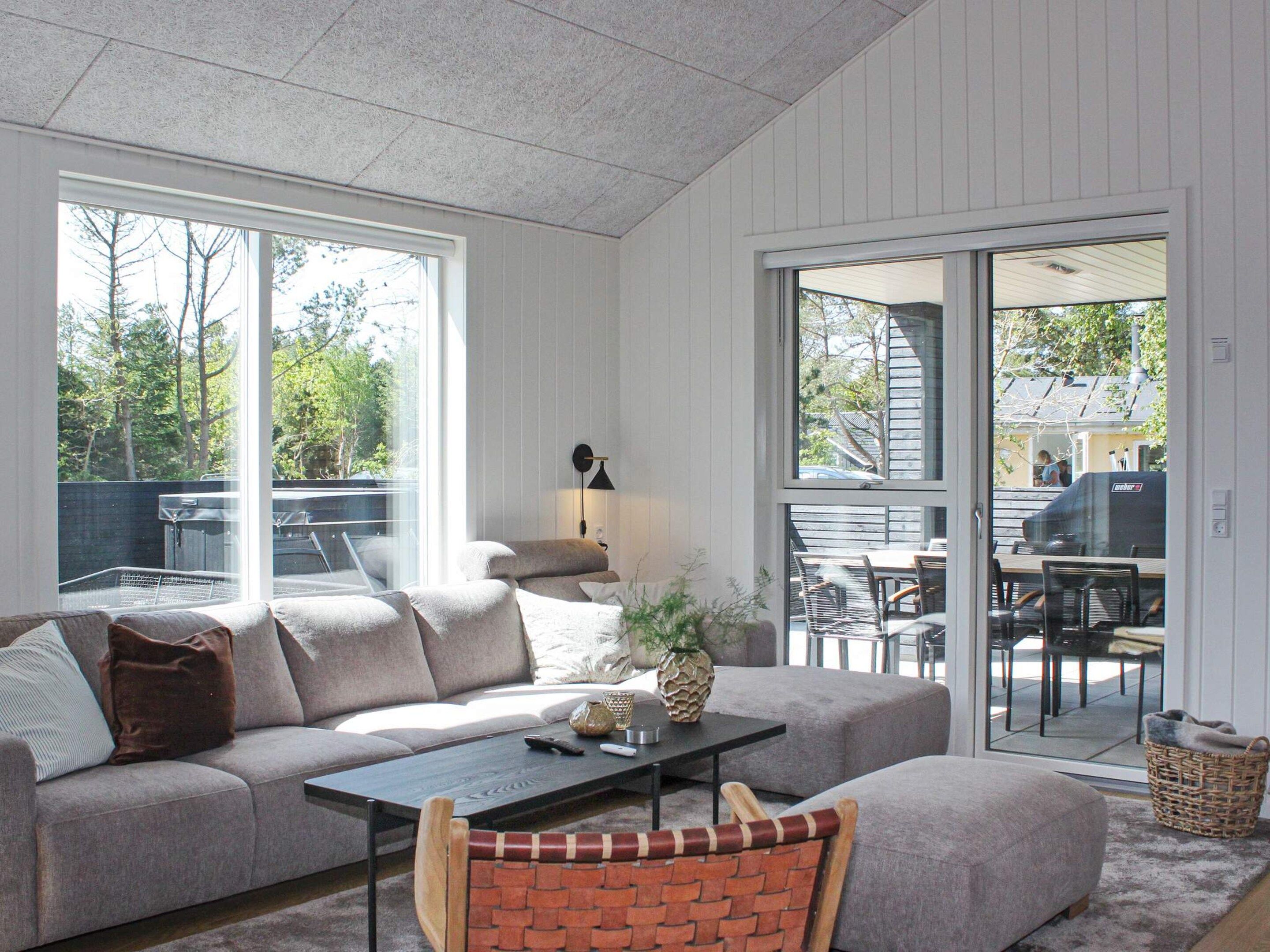 Uma sala de estar moderna com sofá, mesa de centro e poltrona com padrão de tijolos.