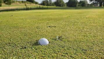 Uma bola de golfe em um campo de grama bem cuidado.