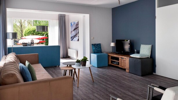 Uma sala de estar moderna com um sofá, uma mesa de centro e um rack para TV.