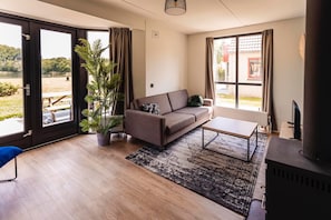 Uma sala de estar moderna com sofá, mesa de centro, planta em vaso e lareira.