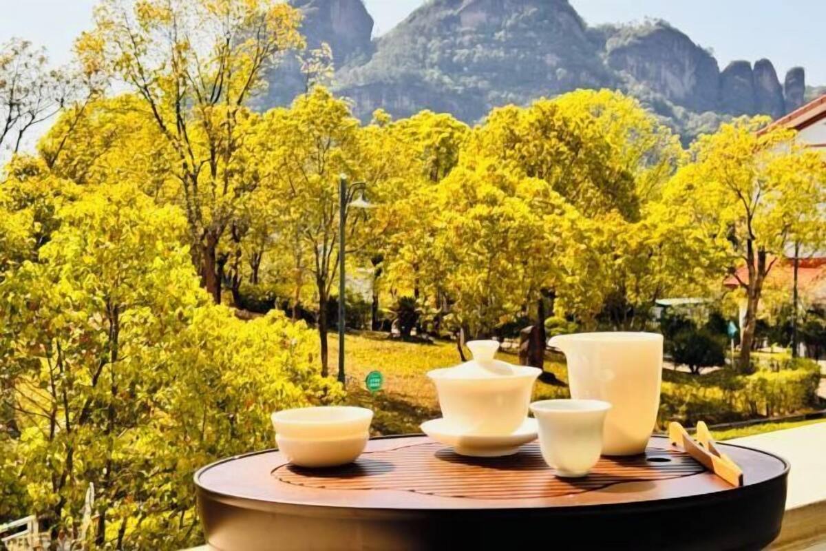 Uma mesa com jogos de chá e vista para uma paisagem montanhosa.