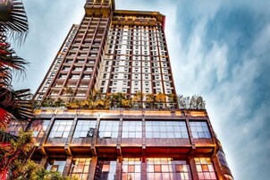 Um edifício alto com vários andares, janelas amplas e design arquitetônico moderno.
