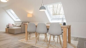 Um apartamento loft moderno com área de jantar, sofá e claraboia.