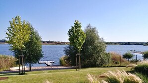 Uma propriedade à beira do lago com gramado, árvores e um píer.
