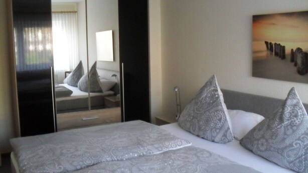 Quarto de hotel com uma cama, um guarda-roupa e um quadro na parede.