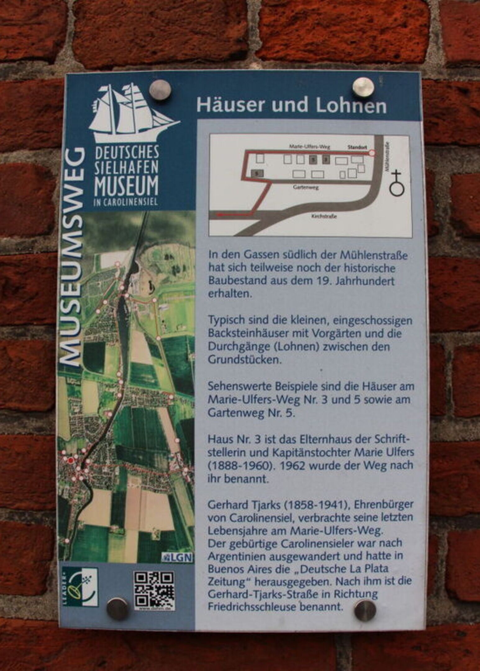 Placa histórica do Museu Deutsches Siehafen em Carolinensiel, descrevendo a localização de casas e ruas ao longo da Mühlenstraße e Marie-Ulfers-Weg.