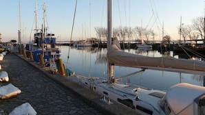 Uma marina com barcos atracados ao longo de um cais de calçamento.