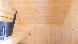 Uma sala de sauna com paredes de madeira e um banco.