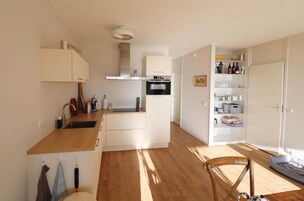 Uma cozinha compacta com forno embutido, pia e bancada de madeira.