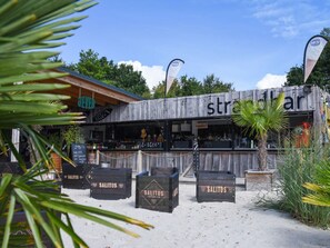 Um bar rústico com fachada de madeira, mesas ao ar livre e um letreiro com a inscrição 'Salitos Imported'.
