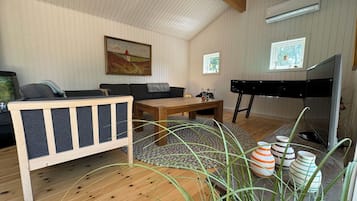 Uma sala de estar aconchegante com um sofá de madeira, uma mesa de centro e um rack para TV.
