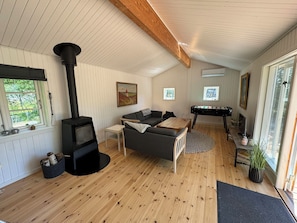 Uma sala de estar acolhedora com lareira, um sofá, uma mesa de centro e uma mesa de futebol.