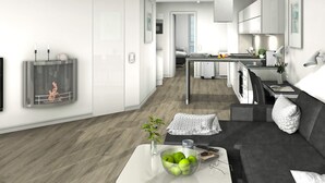 Apartamento moderno com sala de estar, cozinha e área de jantar. Há um sofá, uma mesa de centro com uma tigela de maçãs e uma TV na parede.