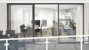 Um interior moderno com área de refeições, cozinha e espaço de estar visíveis através de grandes portas de vidro deslizantes.
