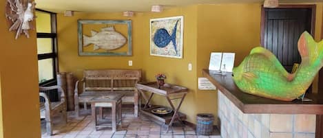 Um quarto aconchegante com um banco de madeira, uma mesa e um mural de peixes na parede.