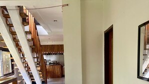 Um corredor com uma escada que dá acesso a uma cozinha.