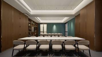Uma sala de conferência com uma mesa longa e cadeiras, painéis de madeira e um design moderno no teto.
