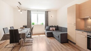 Um apartamento moderno com área de refeições, sofá e cozinha.