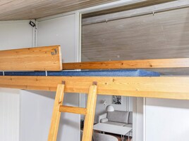 Uma cama beliche com estrutura de madeira e colchão.