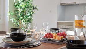 Uma mesa de jantar posta com tigelas, copos e um prato de frutas.