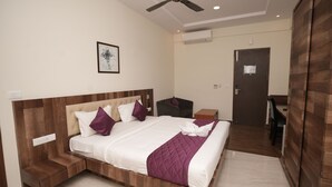 Quarto de hotel moderno com cama de madeira, uma escrivaninha e um guarda-roupa.