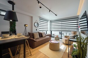 Uma sala de estar moderna com sofá, mesa de centro e área de jantar.