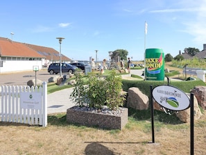 Entrada de um campo de golfe com uma placa indicando 'Adventure Golf' e um grande anúncio de 'Faxen Konni'.
