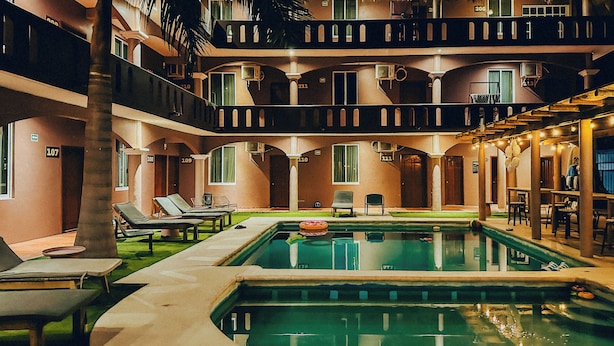 Hotel com piscina, várias varandas e áreas de estar ao ar livre.