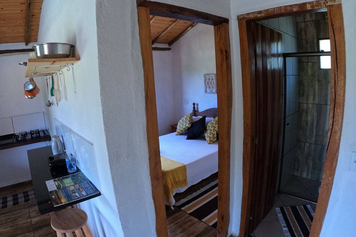 Quarto compacto com cozinha compacta, uma cama e área de chuveiro.
