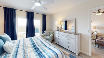 Quarto com cama, cômoda, cadeira e ventilador de teto.