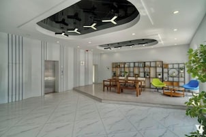Um hall espaçoso com piso de mármore, balcão de recepção, área de estar e design de teto moderno.