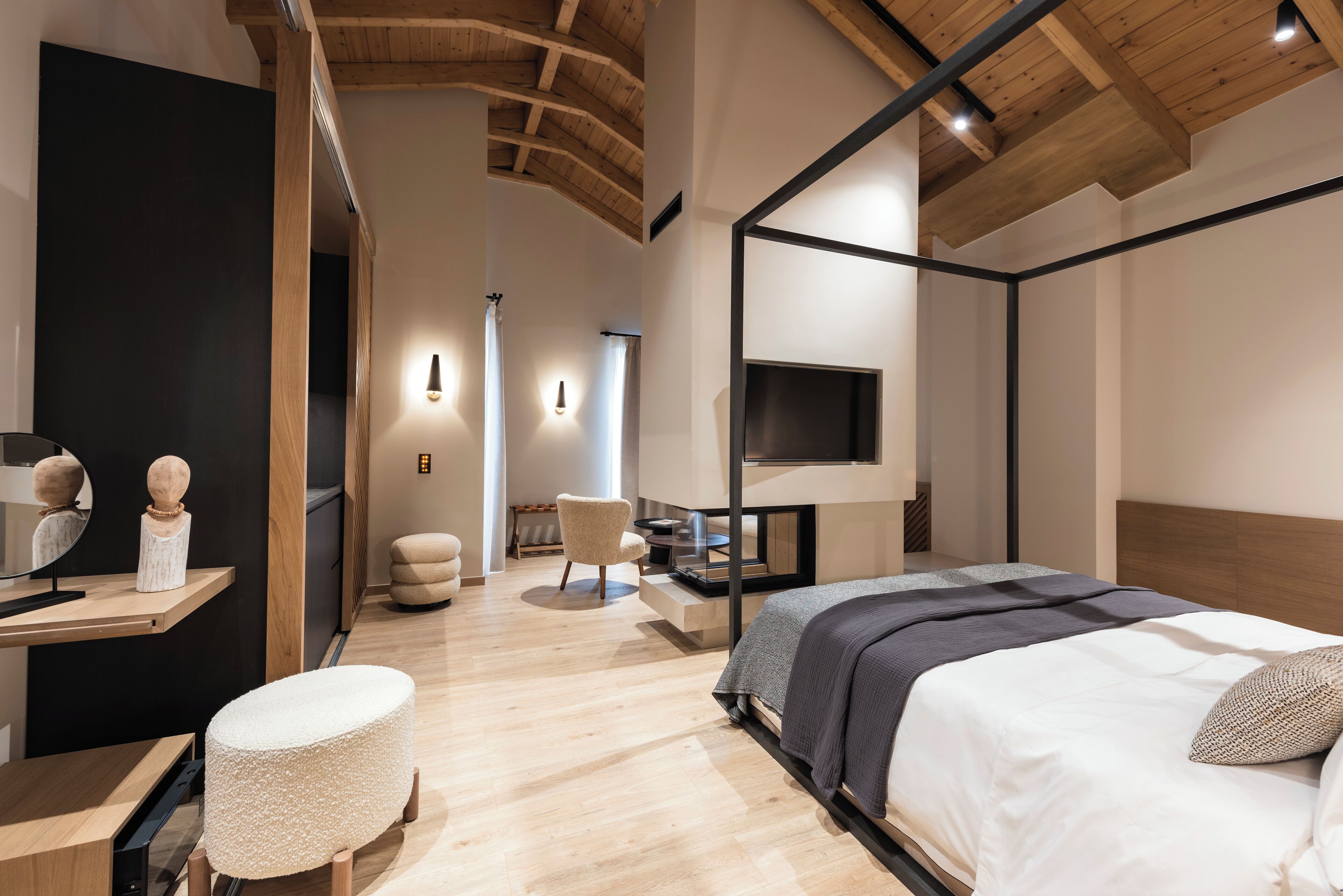 Quarto moderno com uma cama, televisão, escrivaninha e cadeira.