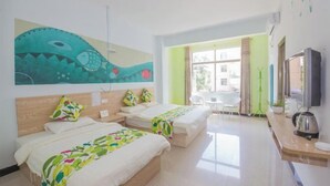 Quarto de hotel com duas camas, televisão e uma janela grande.