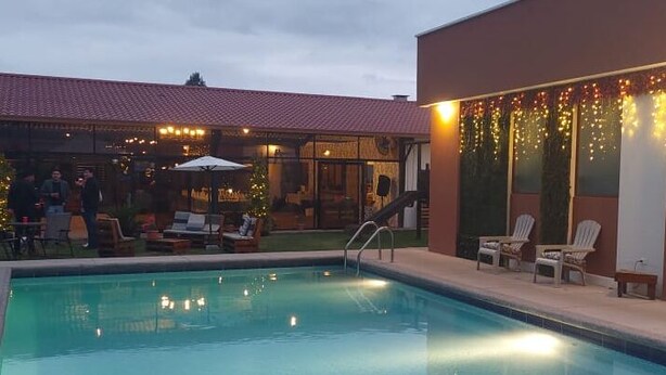 Piscina com espreguiçadeiras e área de estar coberta.