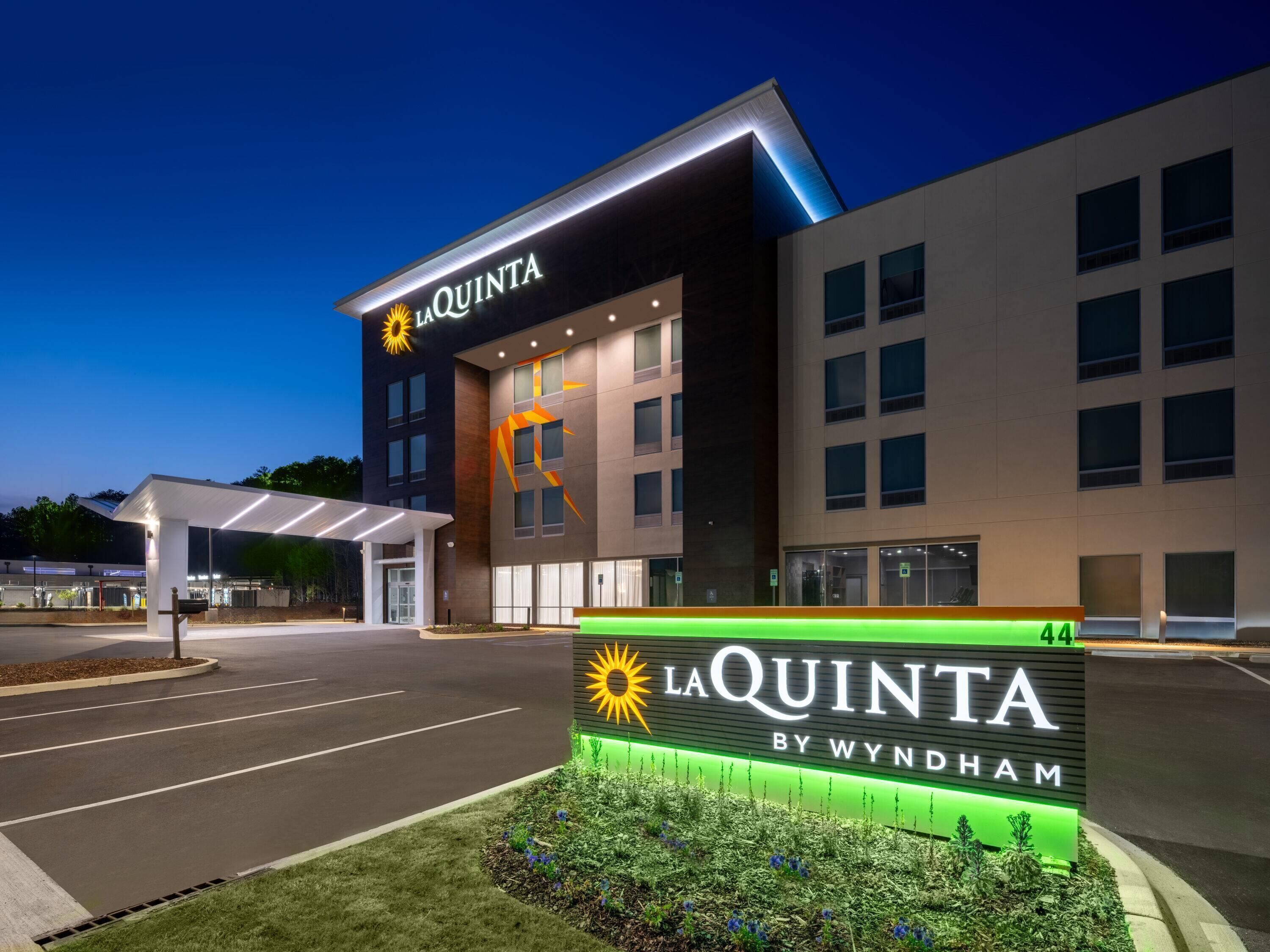 Um edifício moderno de hotel com uma placa de destaque que diz "La Quinta by Wyndham".