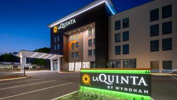 Um edifício moderno de hotel com uma placa de destaque que diz "La Quinta by Wyndham".